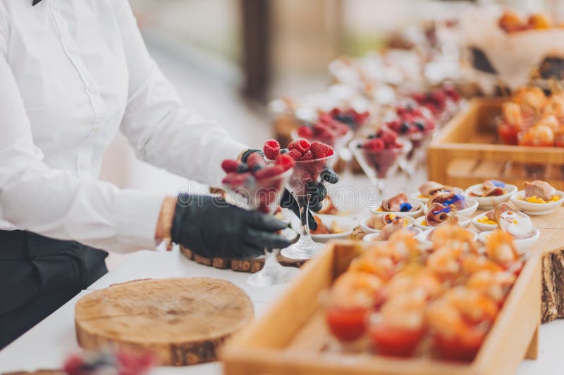 Hands of a Waiter Prepare Food for a Buffet Table in a Restaurant ...