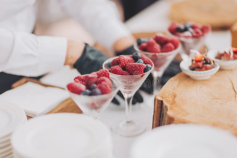 Hands of a Waiter Prepare Food for a Buffet Table. Caterer Arranges ...