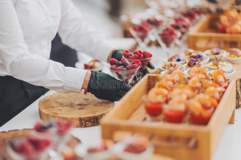 Hands of a Waiter Prepare Food for a Buffet Table in a Restaurant ...