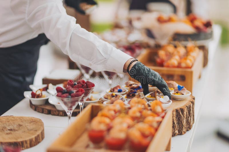 Hands of a Waiter Prepare Food for a Buffet Table in a Restaurant ...