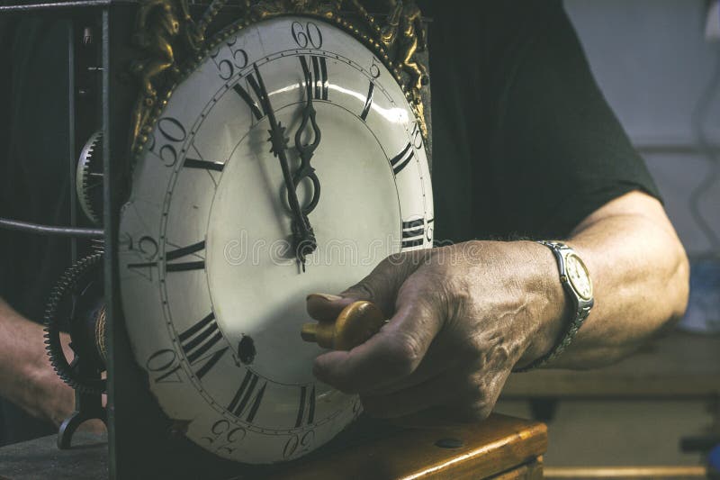 The Hands of a Watchmaker Winding the Hands of a Wall Clock Stock Image ...