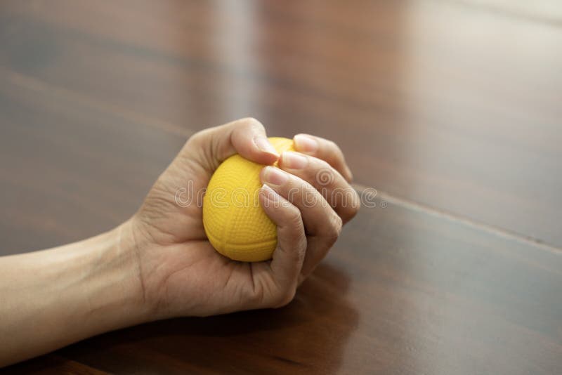Hands of a Woman Squeezing a Blue Stress Ball for Work Out or Relax at ...