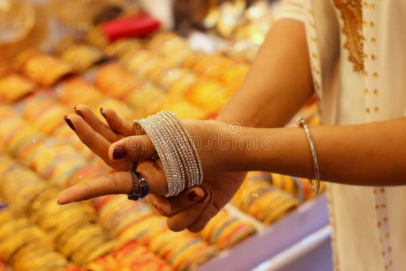 Hands of a Woman Trying To Wear of Bangles on Her Hand.Selective Focus ...