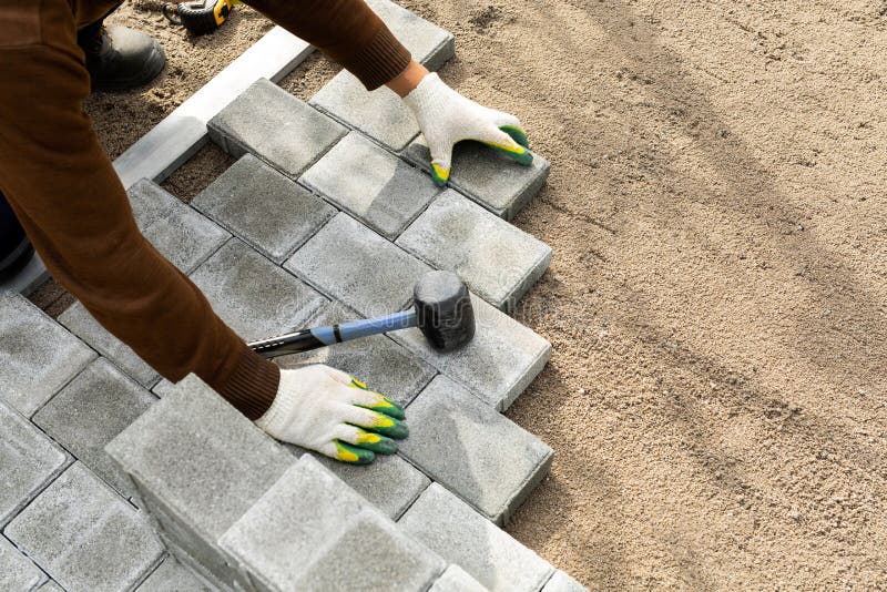 Hands of a Worker Installing Concrete Blocks, Paving Slabs with a ...