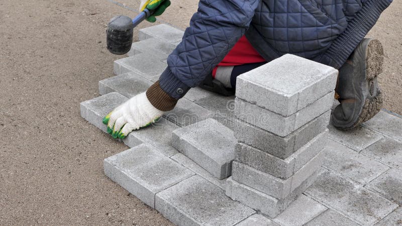 Hands of a Worker Installing Concrete Blocks, Paving Slabs with a ...