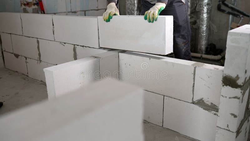 Workers Build a Light Brick Wall at a Construction Site. Wall Building ...