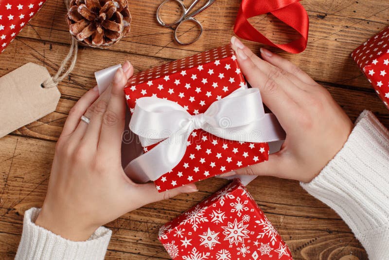 Hands with wrapped present stock image. Image of table - 200152771