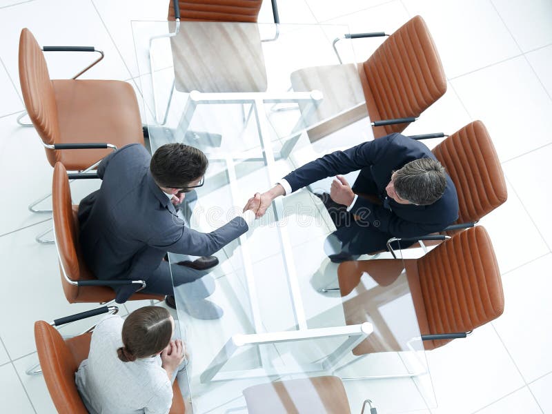 Handshake Across the Table. Meeting Around a Boardroom Table. Stock ...