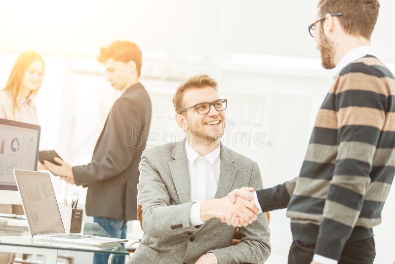 Handshake Colleagues Near the Workplace in the Modern Office. Stock ...