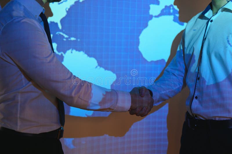 Handshake with Map of the World in Background. Two Businessmen on the ...