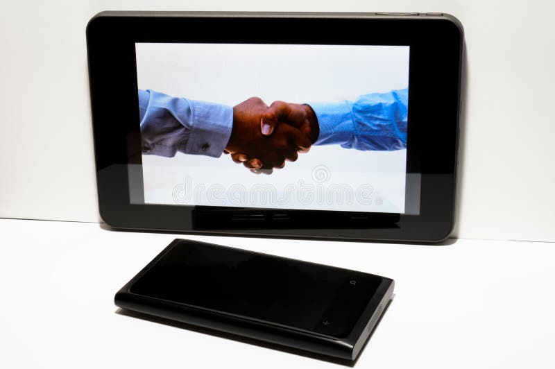 Handshake on Tablet with Smartphone Stock Photo - Image of held ...