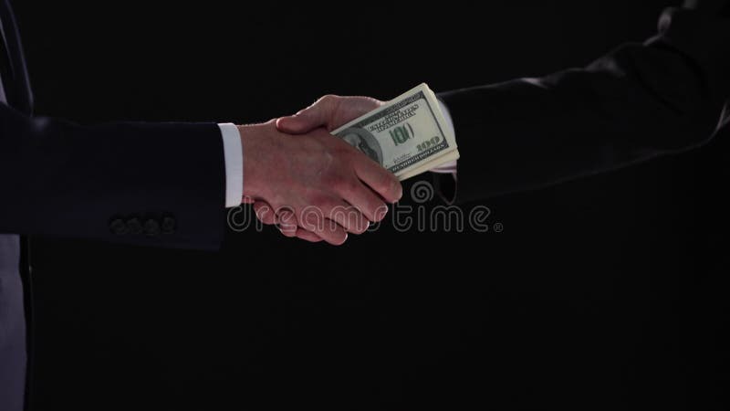 Handshake with the Transfer of Money on a Black Background Stock ...