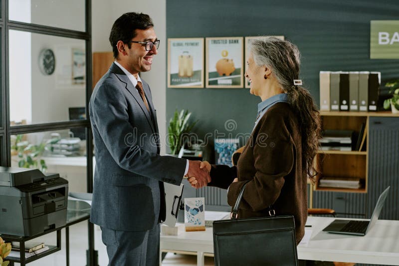Handshaking between Business Colleagues in Office Setting Stock Photo ...