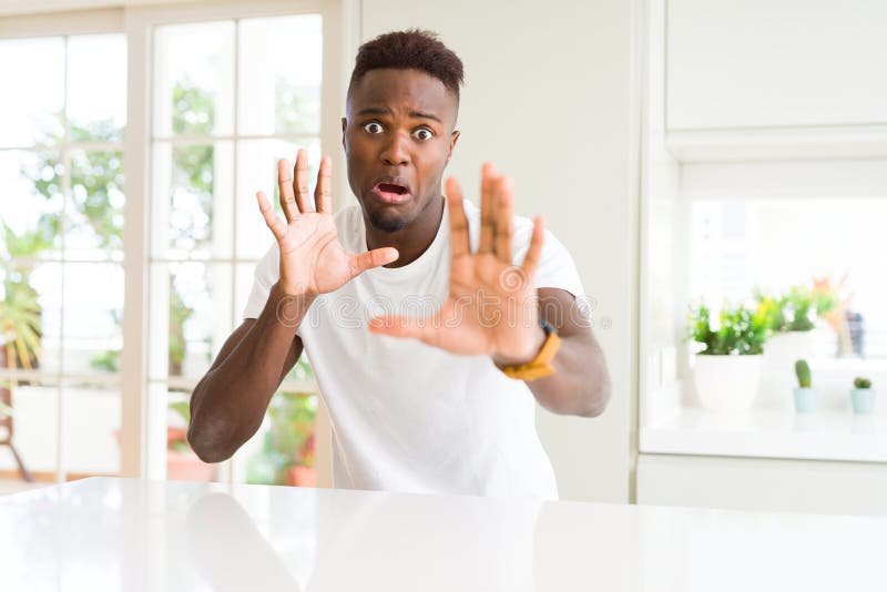 Handsome African American Man on White Table at Home Afraid and ...