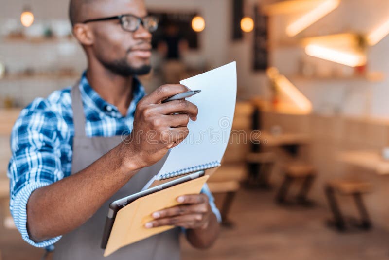 Handsome African American Waiter Taking Order With Notepad And Digital