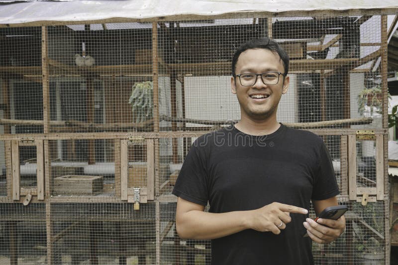 Handsome Asian Man is Smiling and Standing in Front of Bird Cage Stock ...