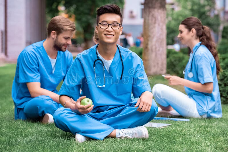 Handsome Asian Medical Student Holding Apple and Looking Stock Image ...