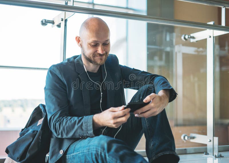 Handsome Bald Bearded Man in Suit Using Mobile Phone at the Airport ... Handsome Bald Bearded Man in Suit Using Mobile Phone at the Airport ...