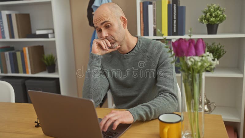 Handsome Bald Man with Beard Contemplating while Using Laptop in a ...