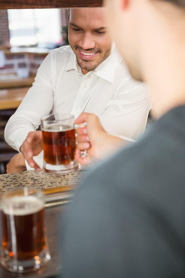 Handsome Bar Tender Giving a Pint To Customer Stock Image - Image of ...