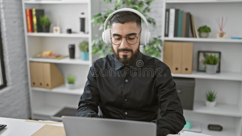 Handsome Bearded Man in Headphones Working on Laptop at Modern Office ...
