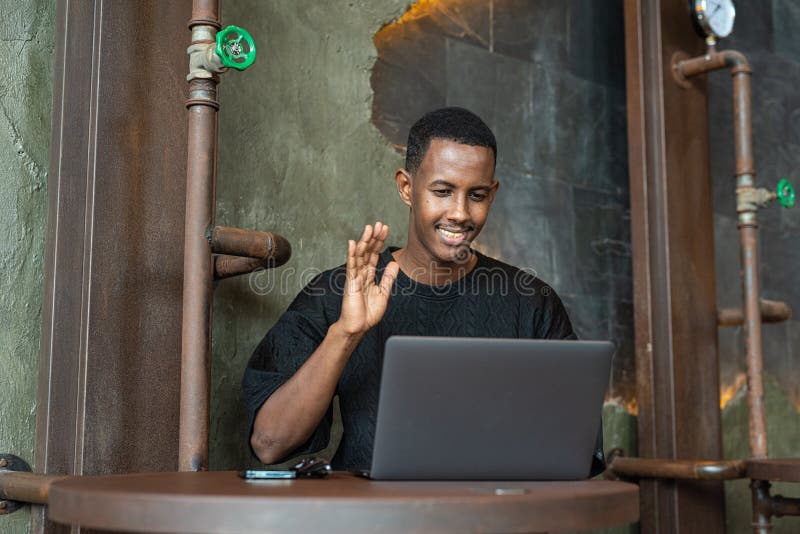Handsome Black Man Sitting and Using Laptop Computer Indoors Stock ...