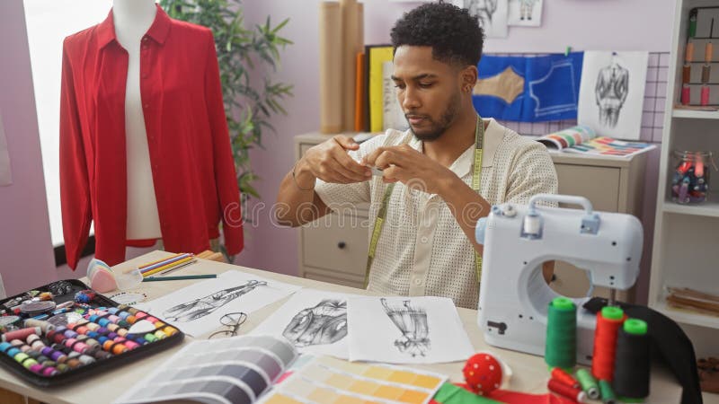 Handsome Black Man Tailoring in a Design Room with Sketches, Colorful ...