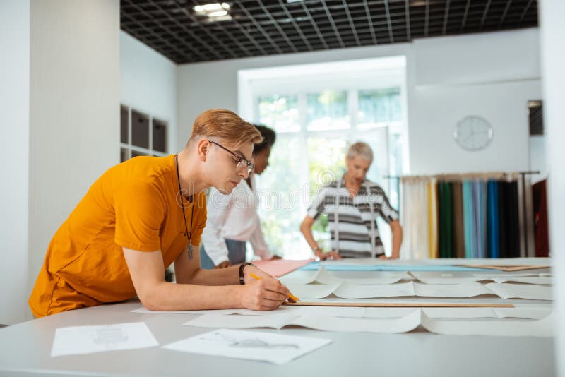 Handsome Blond Young Man Drafting a Sewing Pattern Stock Image - Image ...