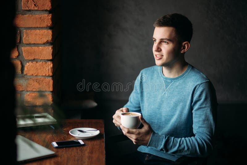 Handsome Boy Drinking Coffee in Cafe. he Sits Near the Window with ...