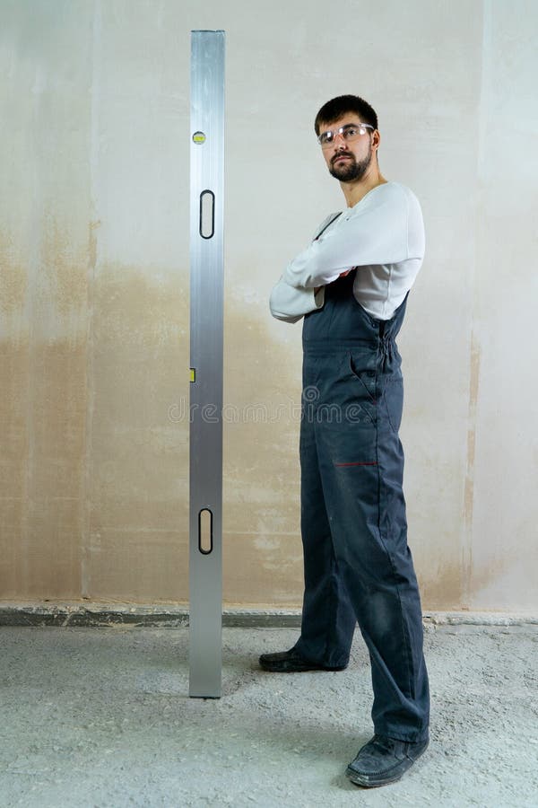 Handsome Builder with Arms Folded Stands Near Empty Wall with ...