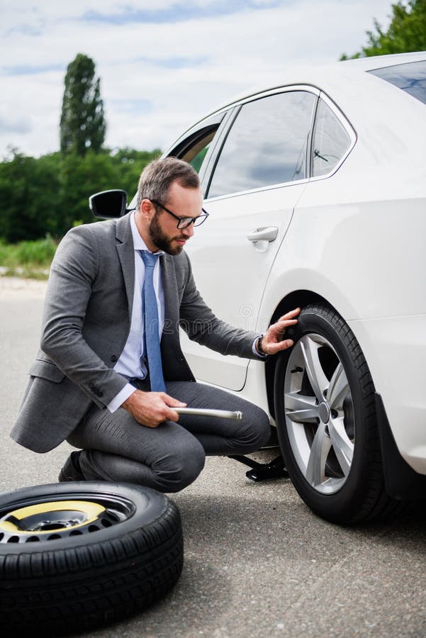 Businessman Changing A Tire Stock Photo - Image of change, driver: 3426954