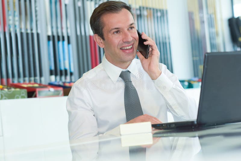 Handsome Businessman Using Computer Talking on Mobile Phone Stock Photo ...