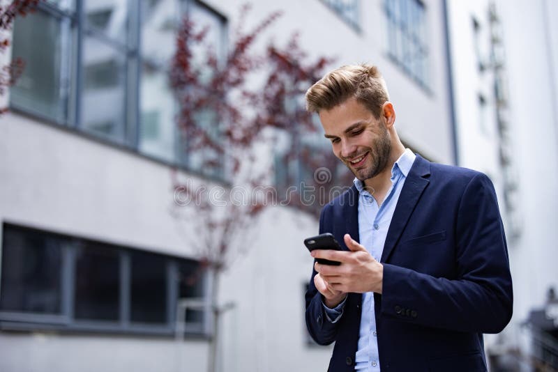Handsome Businessman Using Smartphone and Smiling. Happy Young Man ...