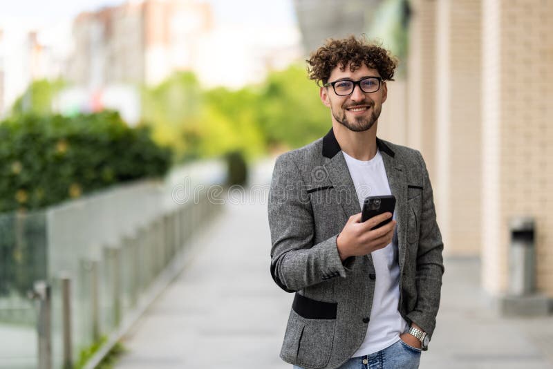 Handsome Businessman Walking in the Street, Using His Phone Outdoors ...