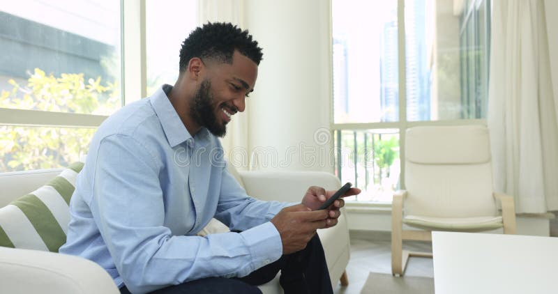 Handsome Cameroonian Young Single Man Sits on Couch with Smartphone ...
