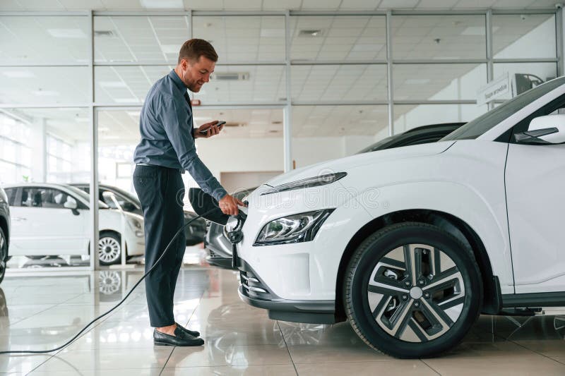 Handsome Car Dealership Worker is with Electric Vehicle Stock Image ...