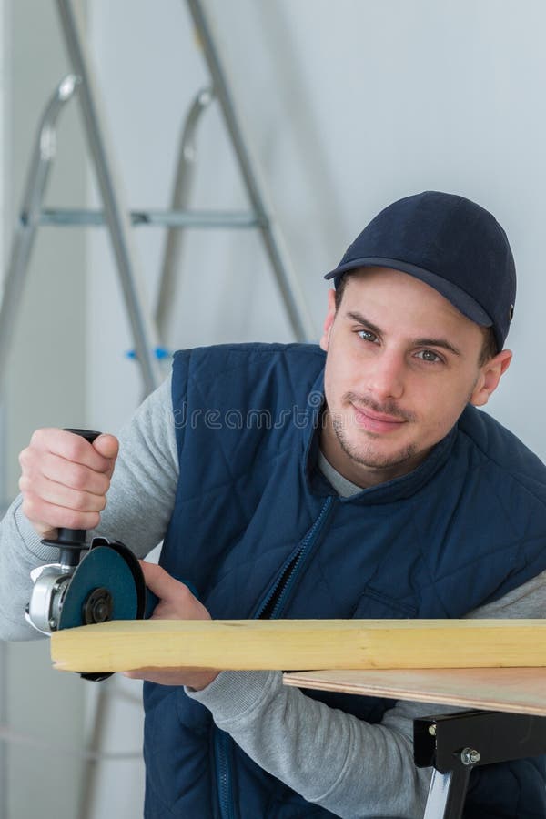 Handsome Carpenter Using Grinder on Plank Stock Photo - Image of ...