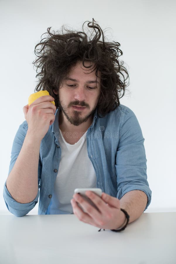 Young Man Eating Apple and Using a Mobile Phone at Home Stock Image ...