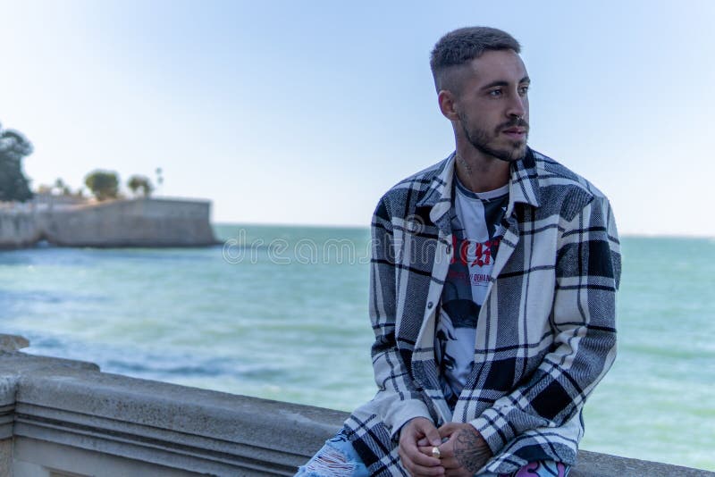 Handsome Caucasian Man Sitting on a Bridge. Stock Image - Image of ...