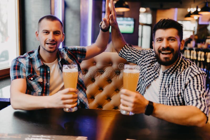 Handsome Cheerful Friends Giving High Five while Drink Beer in Pub ...