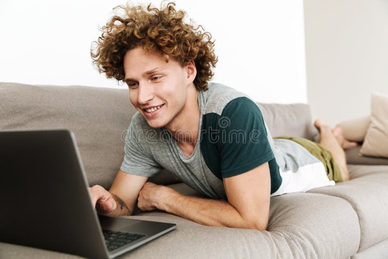 Handsome Cheerful Man Lies on Sofa Using Laptop Computer Stock Photo ...