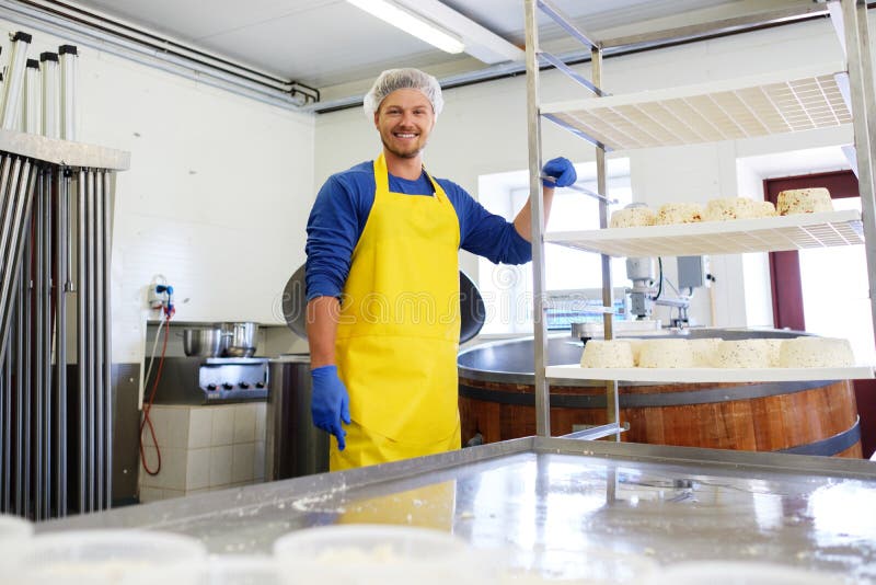 Handsome Cheesemaker Is Checking Cheeses In His Workshop Storage. Stock ...