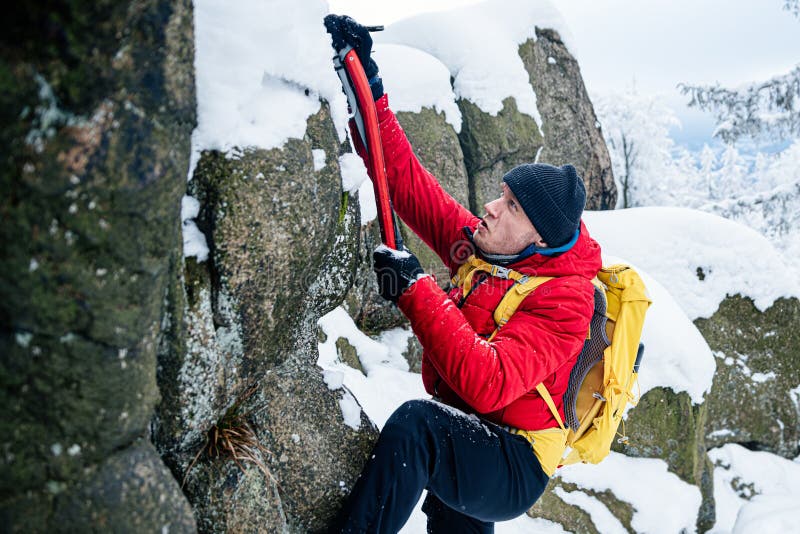 Handsome Climber in a Red Down Jacket and Yellow Backpack Climbs Rocks ...