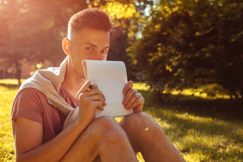 Handsome College Man Writing Notes in Copybook in Campus Park. Happy ...