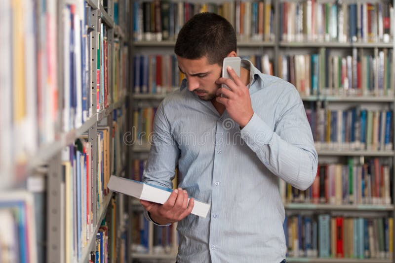 Handsome College Student Using Mobile Phone in Library Stock Photo ...