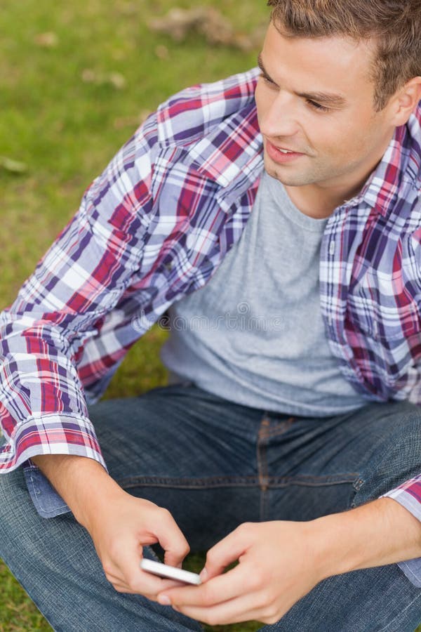 Handsome Content Student Sitting on Grass Texting Stock Image - Image ...