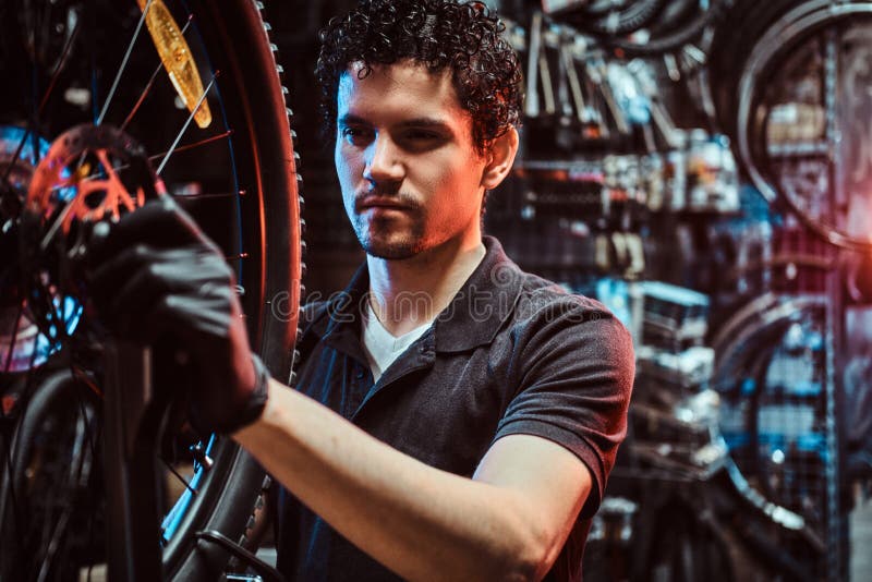 Handsome Diligent Master is Fixing Bicycle`s Wheel at His Workplace ...