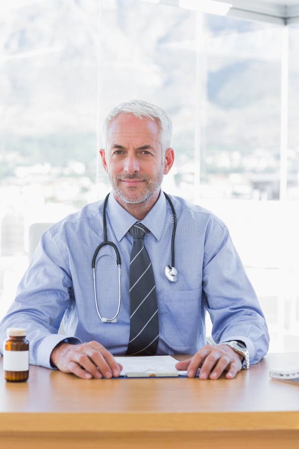 Handsome doctor sitting stock image. Image of office - 31553449