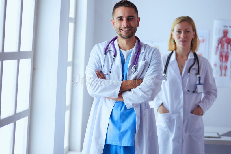 Handsome Doctor is Talking with Young Female Doctor and Making Notes ...
