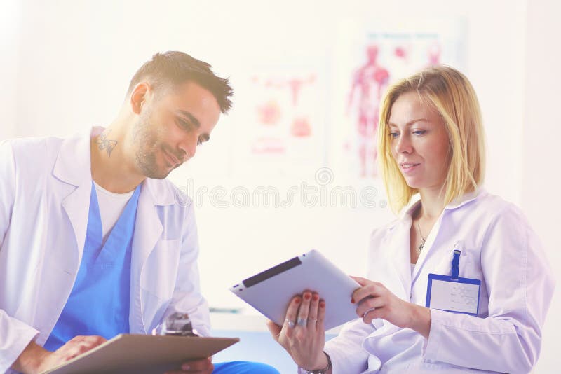 Handsome Doctor is Talking with Young Female Doctor and Making Notes ...